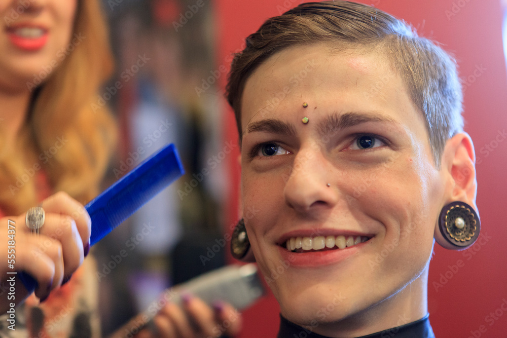 Trendy man with a spinal cord injury at a hair salon getting a hair cut ...