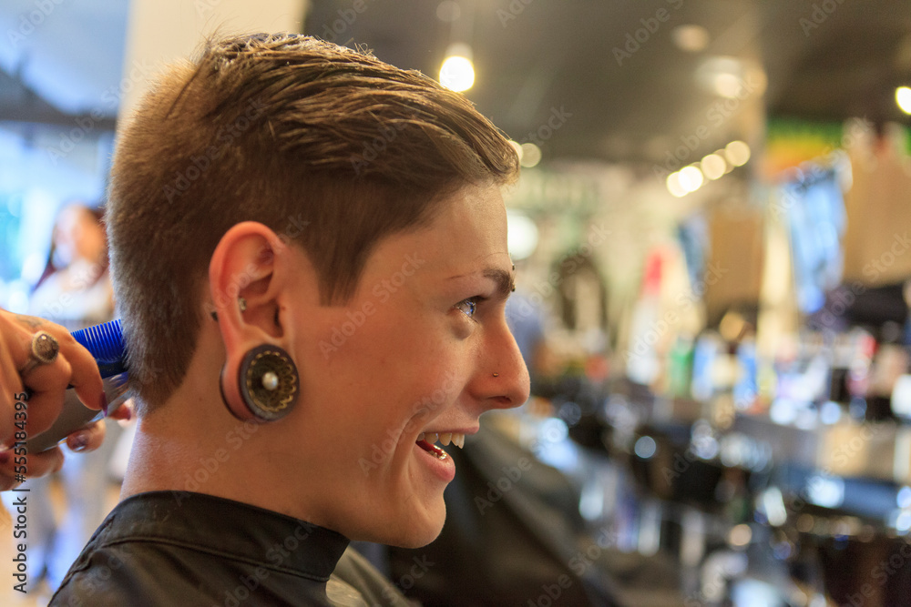 Trendy man with a spinal cord injury at a hair salon getting a hair cut ...
