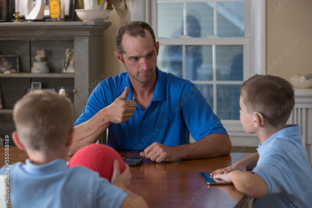 Father communicating to sons in American Sign Language about 'Cool and ...