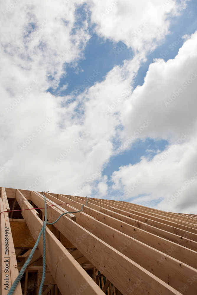 Safety ropes hanging from roof trusses at a house under construction ...