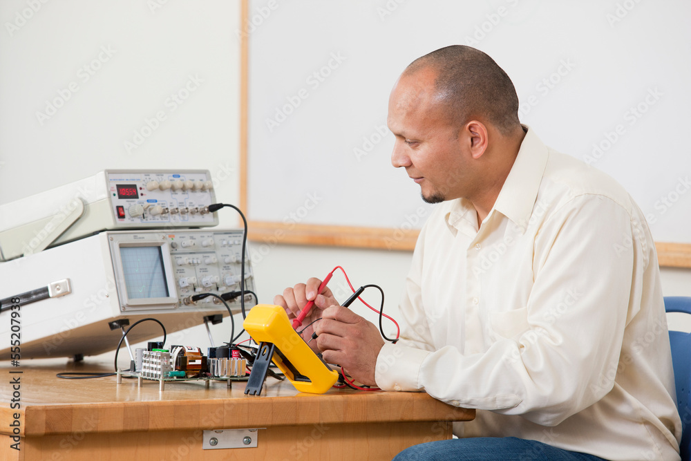 Engineering using multimeter probes to measure circuit characteristics ...
