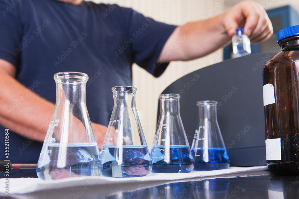 Engineer with sample bottles of indigo solution and ozonated water and ...