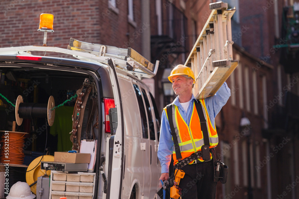 Cable installer preparing to climb the line with ladder Stock Photo ...