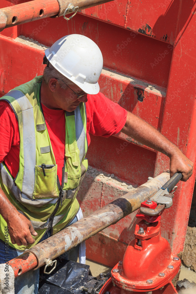Construction worker using wrench to open gate valve Stock Photo | Adobe ...