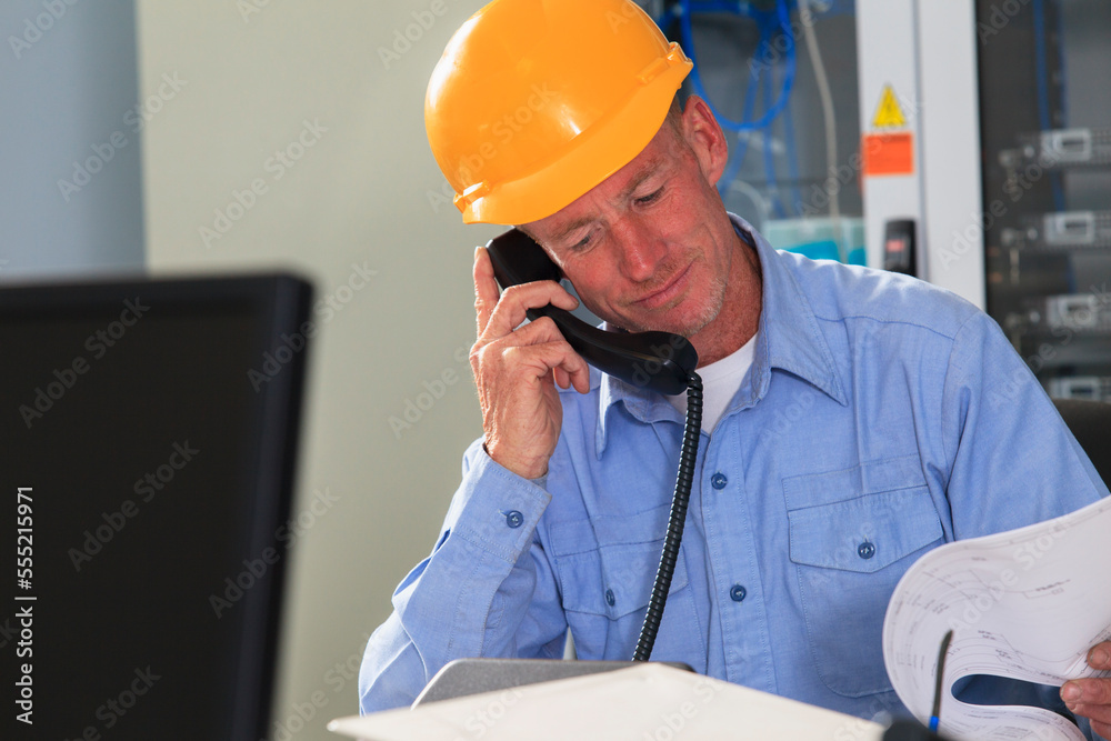 Electrical engineer reviewing process diagrams in operations room of ...