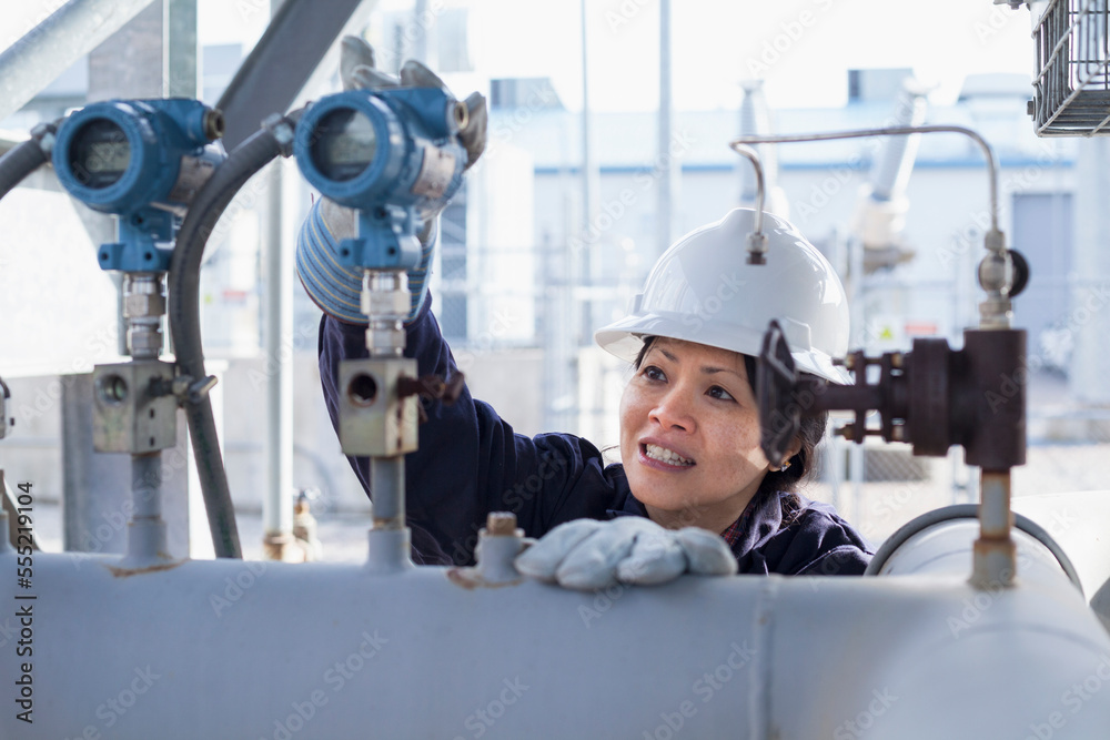 Female power engineer checking pressure transducers at power plant ...