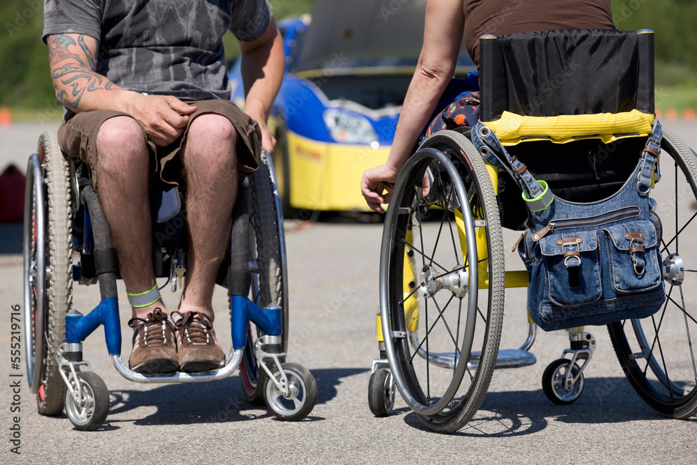 Two disability auto racers on wheelchairs, low section, car in ...