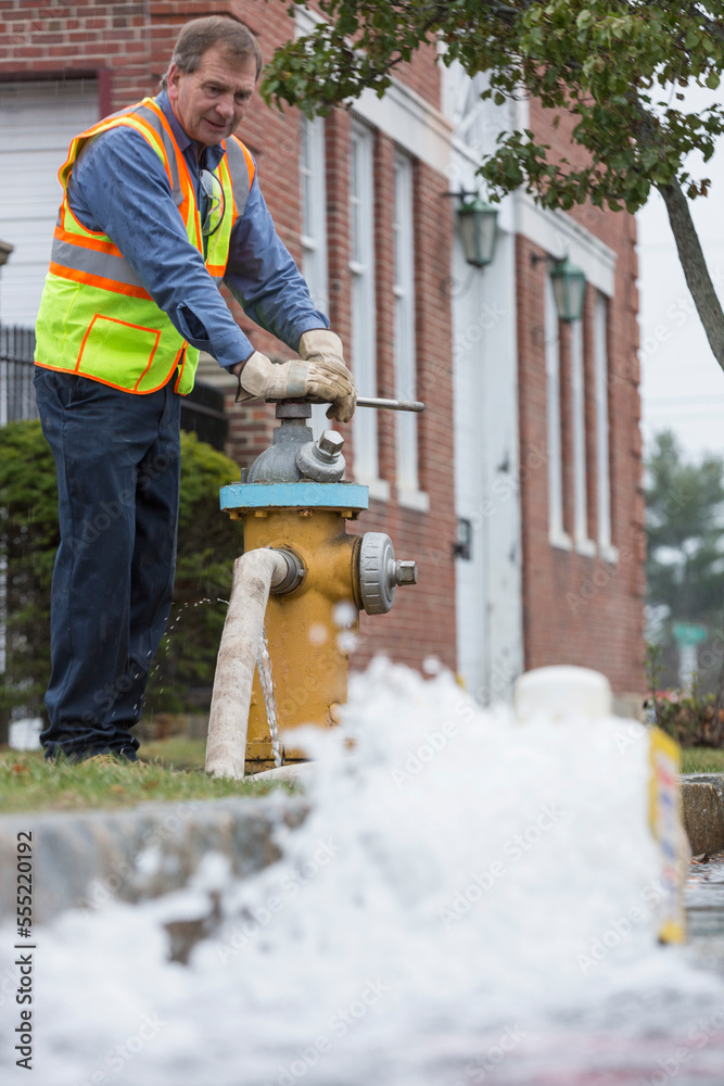 Water department technician opening fire hydrant to flush water mains ...