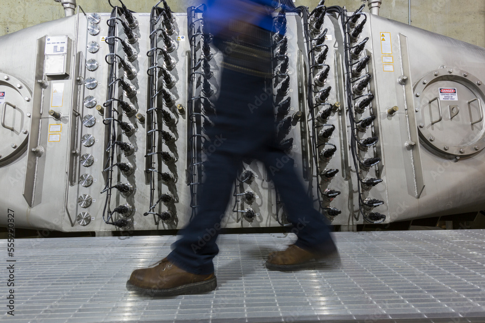 Engineer walking by water treatment plant ultraviolet ionization ...