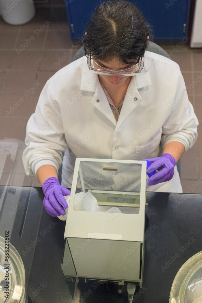 Lab technician adding reagent to scale balance Stock Photo | Adobe Stock