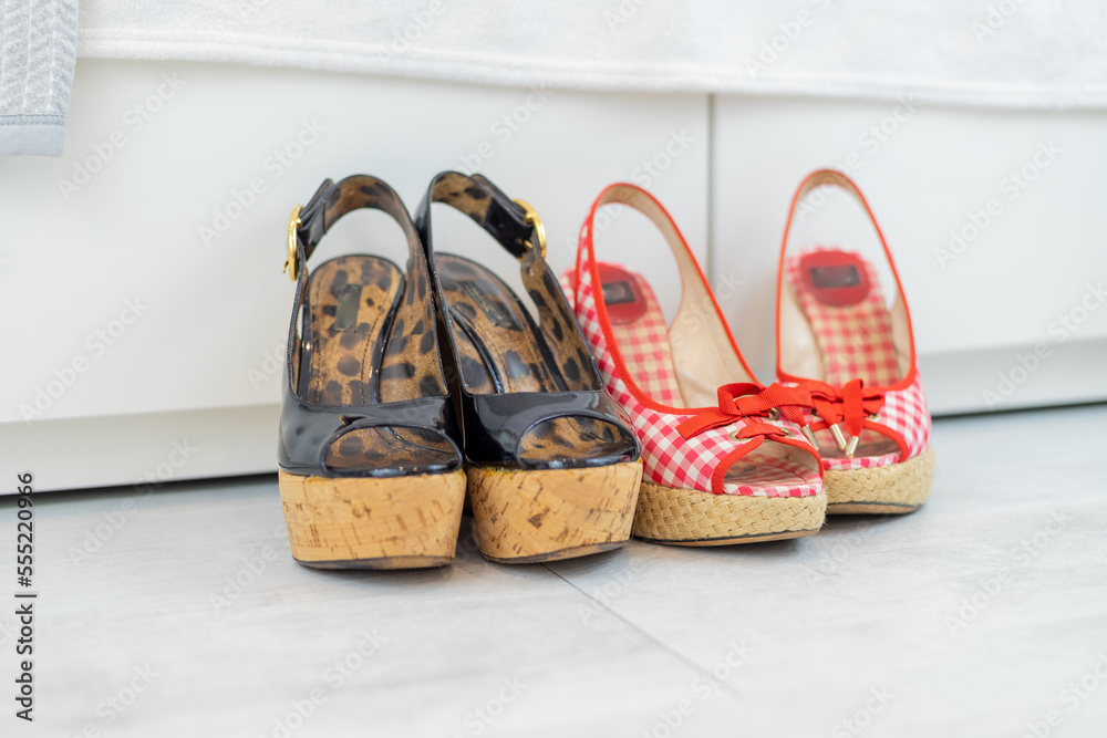 Red and Black pair of open shoes with a high wedge heel in front of a ...