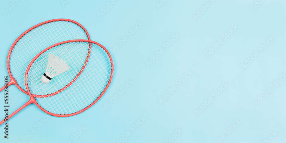 Two badminton rackets on colored background and a badminton ball in ...