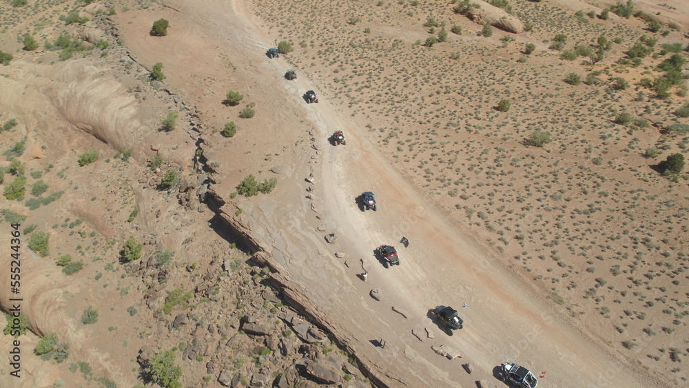 High angle aerial of UTVs off roading in Moab, Utah on red slick rock ...