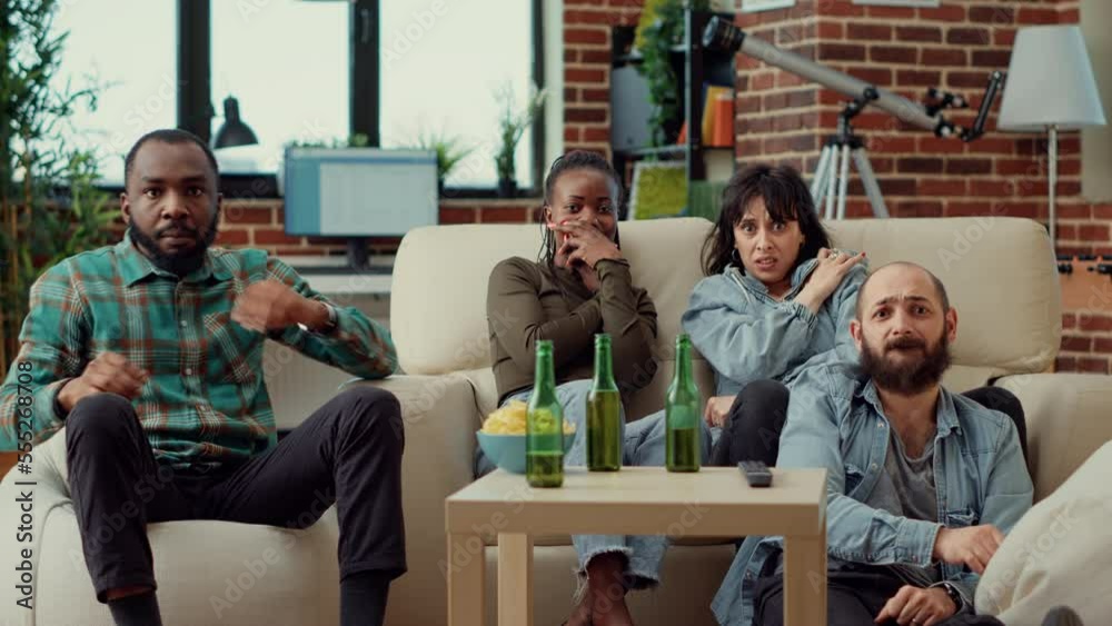 Vidéo Stock Terrified group of friends watching horror movie on ...