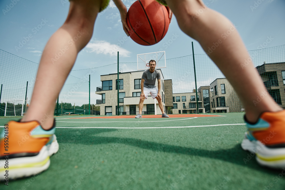 Father and son playing basketball shot through boys legs defending ball ...