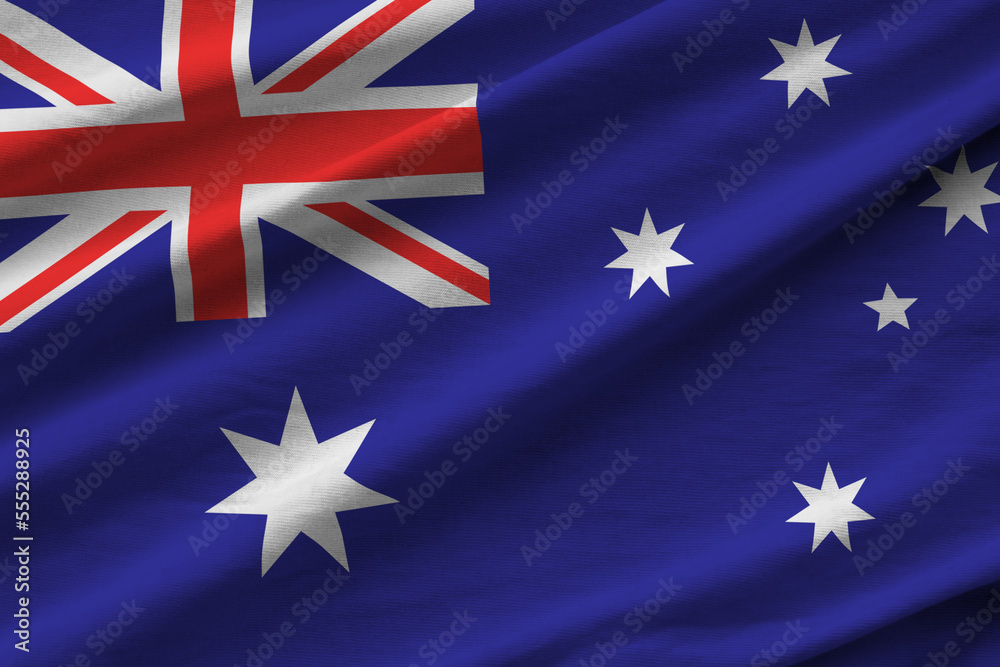 Australia flag with big folds waving close up under the studio light ...
