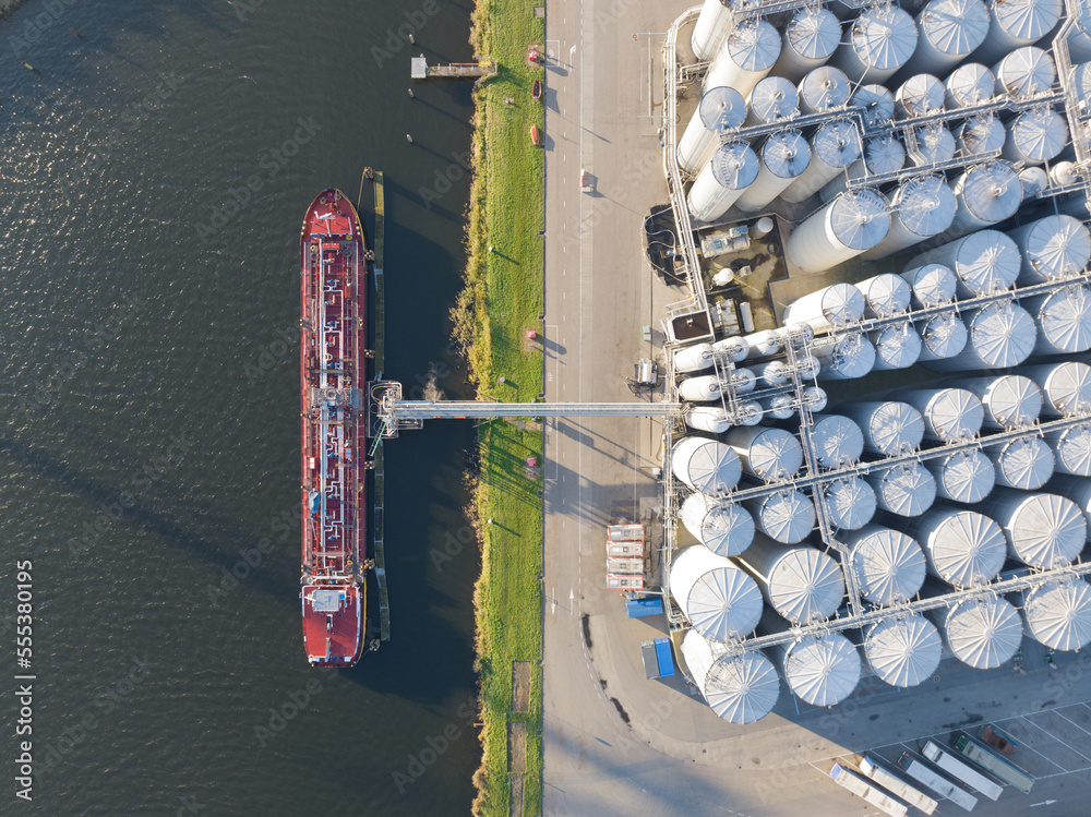 Petrochemical loading of ship at loading dock with pipelines and ...