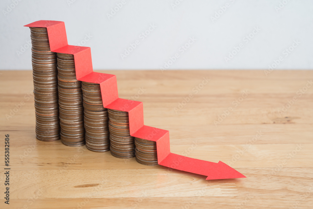 Stack of coins bar chart and red stair graph trending downwards with ...