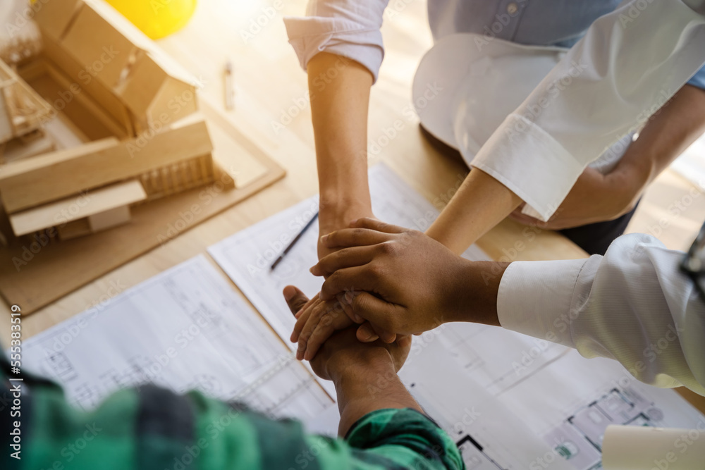 Team architects workers, men and women, join hands to join forces to ...