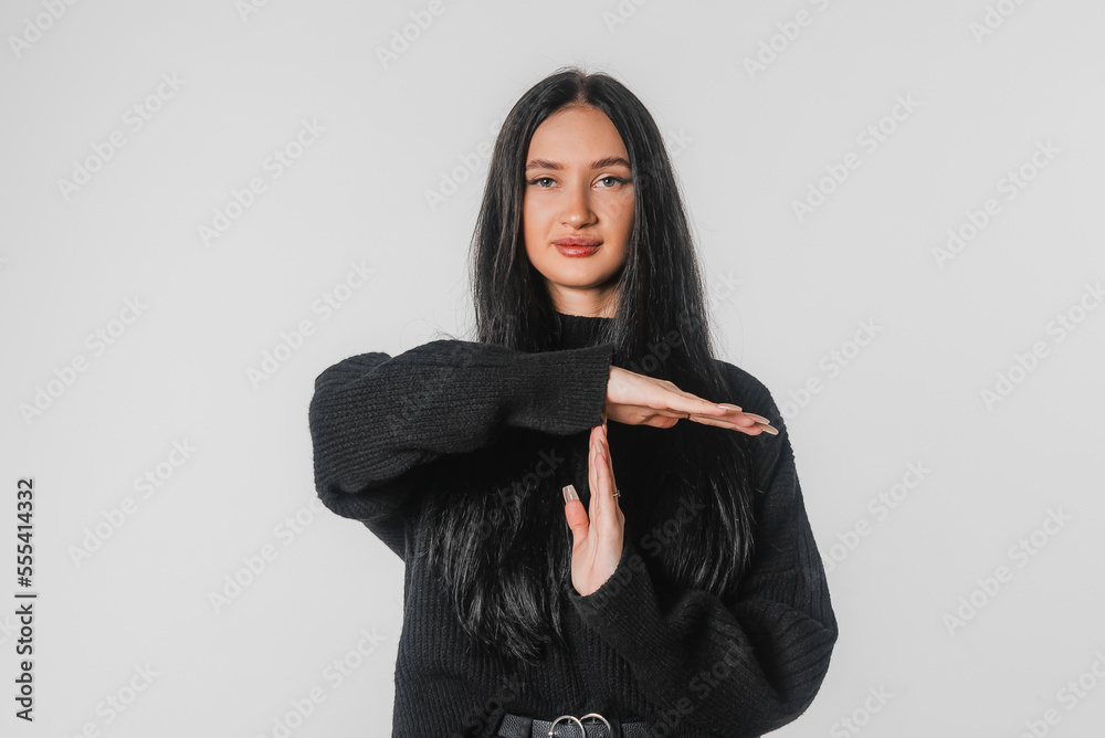Young woman showing time out hand gesture to stop something, standing ...
