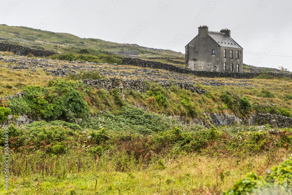 A house sitting alone on a sloped landscape, West Coast of Ireland at ...