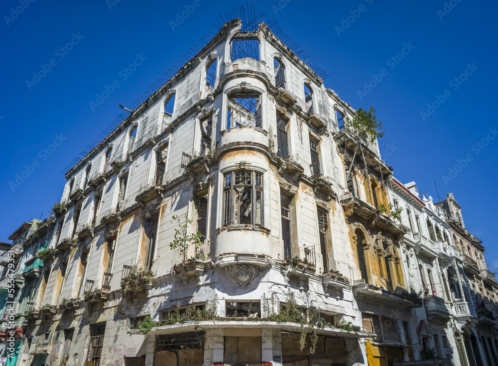 Corner of an old abandoned building with broken windows and rebar ...