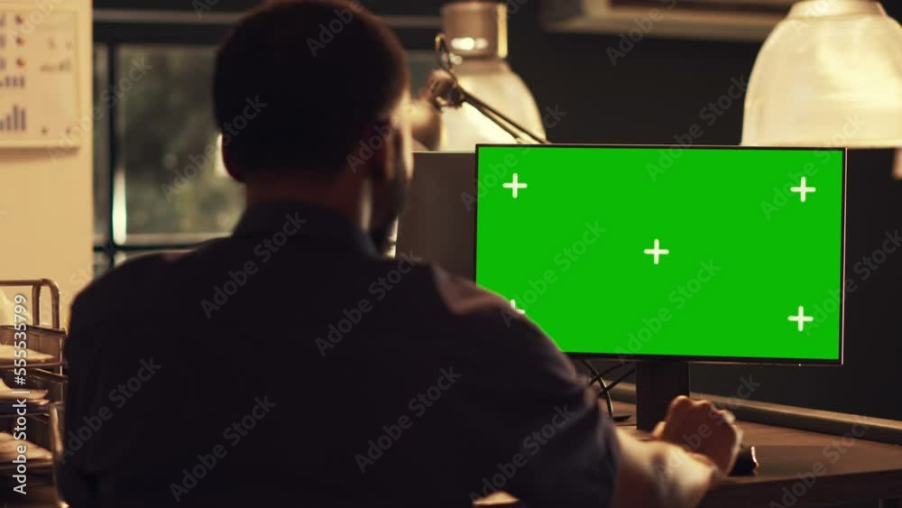 Successful office worker analyzing computer with greenscreen, looking ...