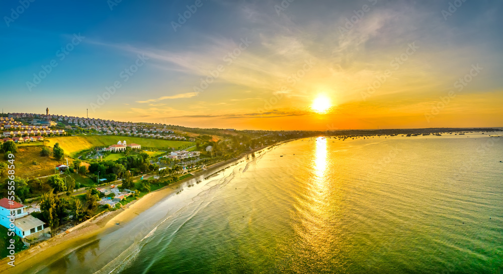 Dawn on the beach with tilted coconut trees, long sandy beach and ...