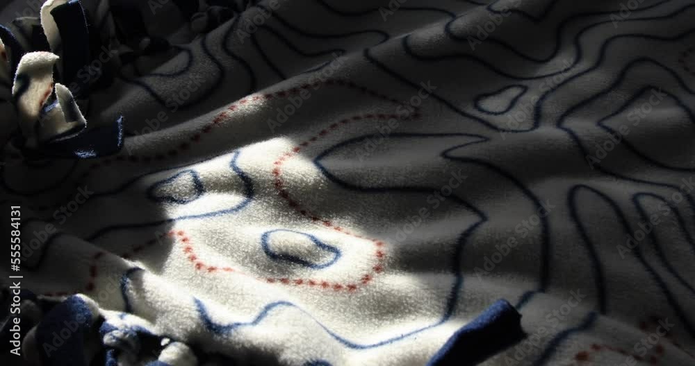 Cool topographic design on a bed throw with dramatic lighting and ...