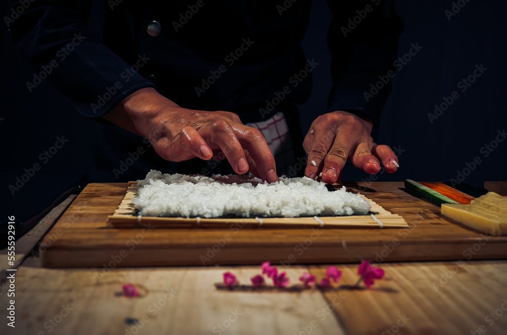 Japanese chef making California Maki Sushi with Masago - Roll made of ...