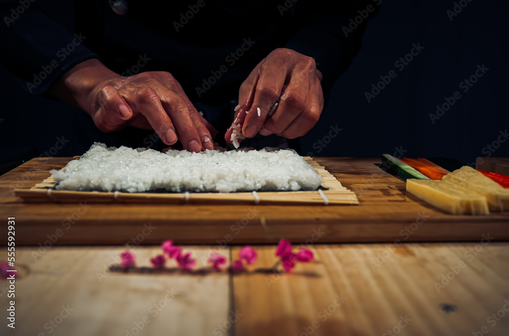 Japanese chef making California Maki Sushi with Masago - Roll made of ...