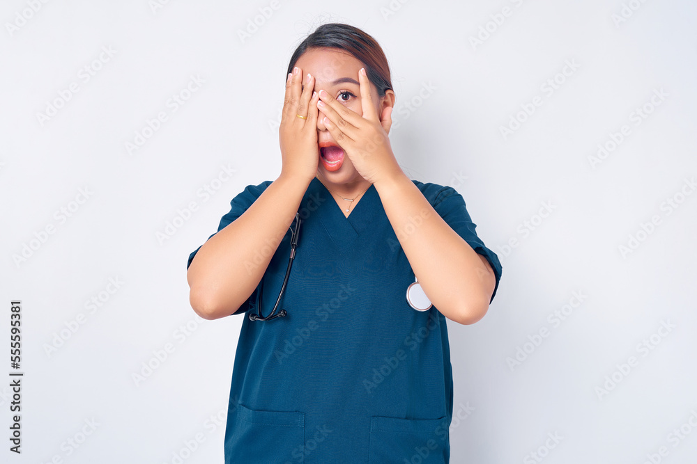 Scared and shocked young Asian woman nurse wearing blue uniform with a ...