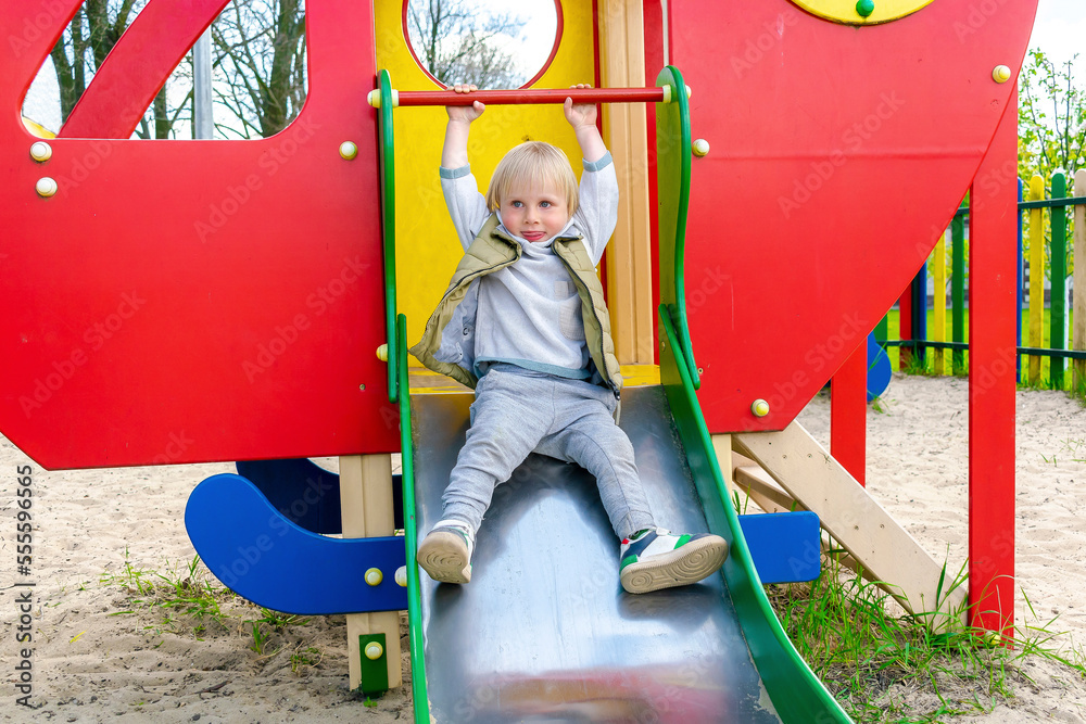 little toddler kid child boy going down slide in playground. Children ...