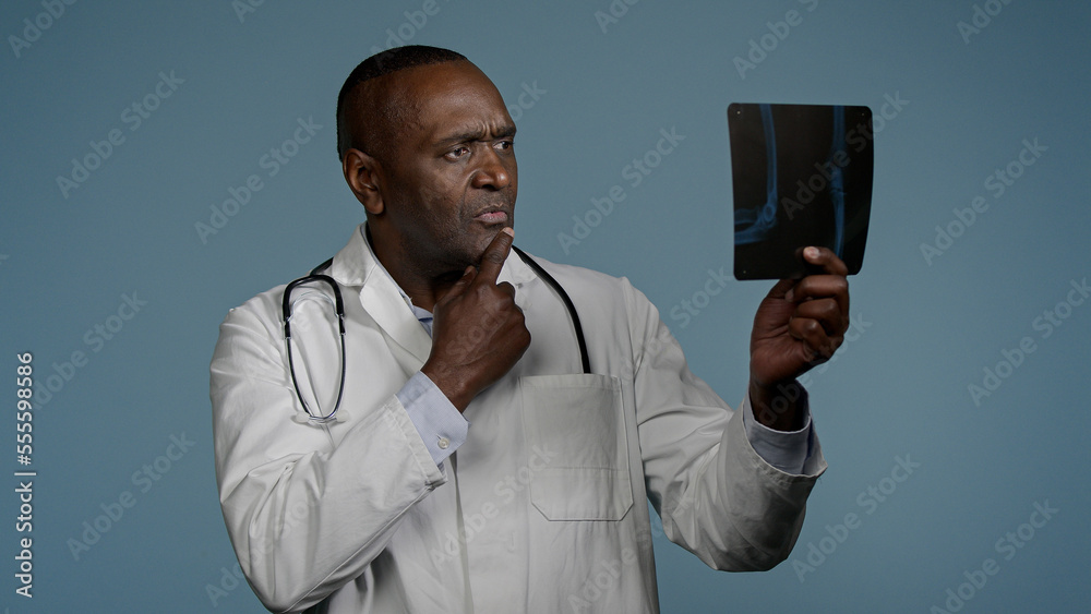 Mature serious man radiologist doctor examining x-ray check results ...