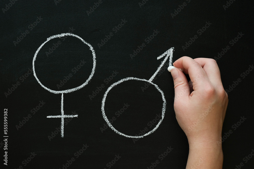 Symbols of male and female gender drawn in chalk on the blackboard ...