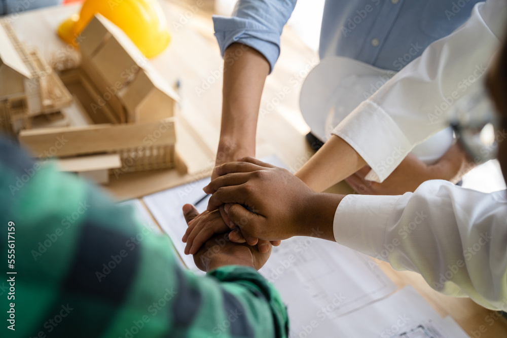 Team architects workers, men and women, join hands to join forces to ...