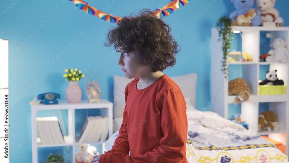 A boy is worried and scared when he sees scary shadows or objects in ...