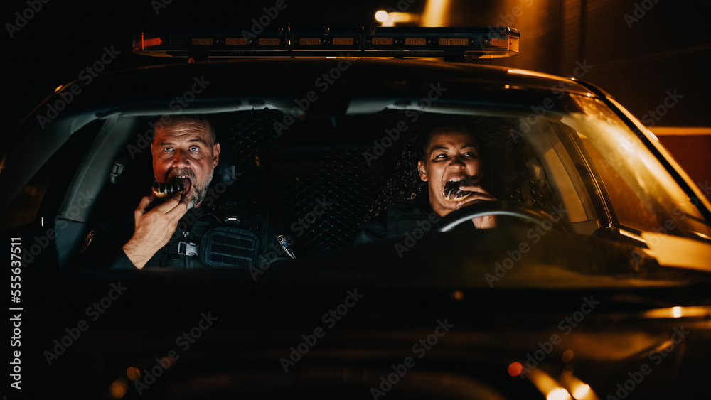 Two Police Officers Sitting in Traffic Patrol Car, Eating Donuts ...