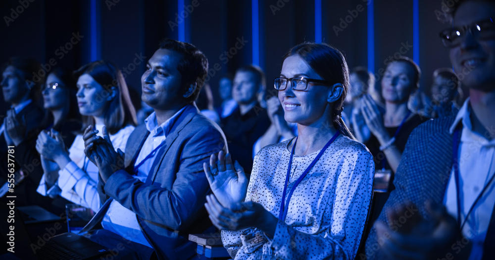 Fototapeta Young Woman Sitting in a Crowded Audience at a Business ...