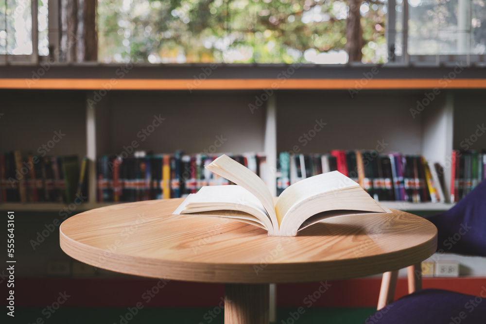 An open book or textbook in the library with light from the window on ...