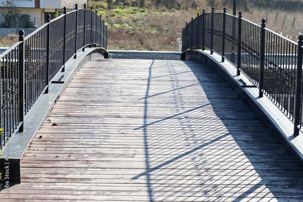 Convex and iron railings of wooden paved footbridge reinforced with ...
