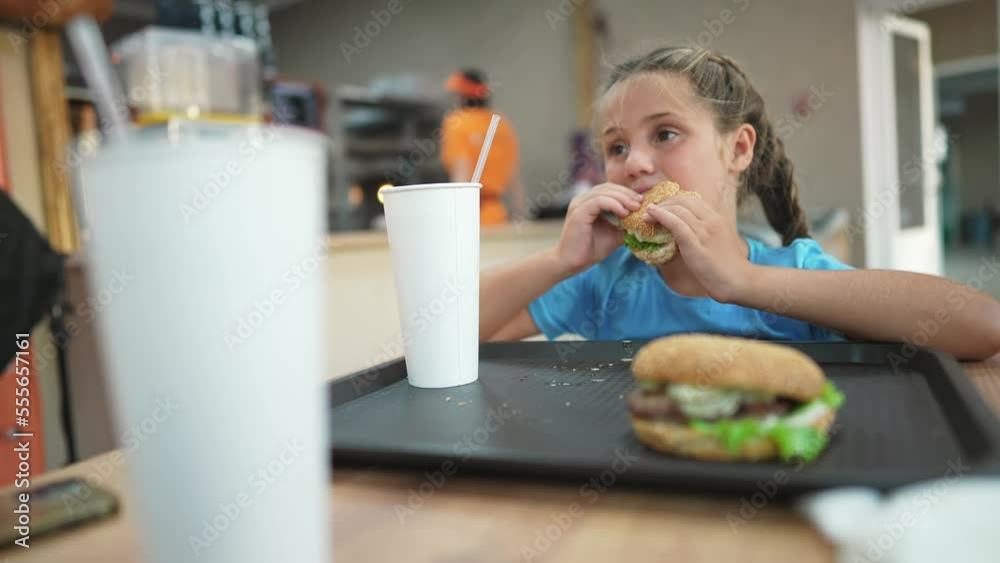 child kid eating a burger in a cafe. fast food nutrition health concept ...