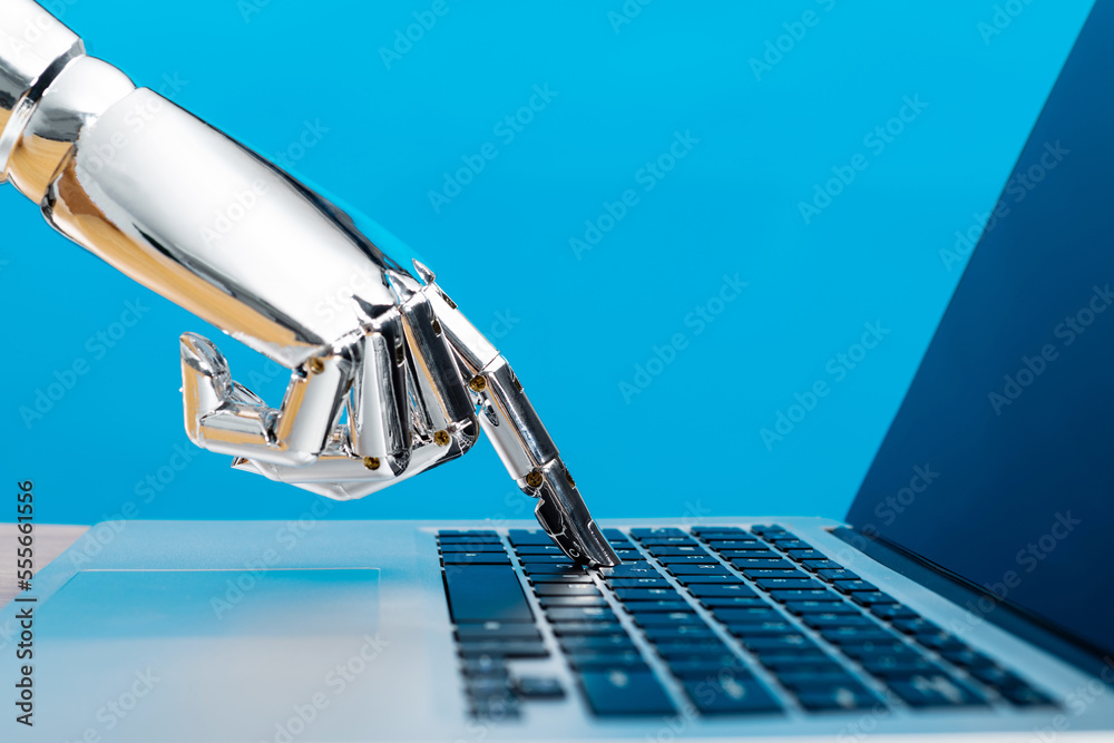 Robot hand typing on laptop Stock Photo | Adobe Stock