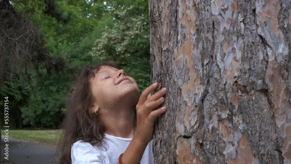 Child admire oak. A smiling little girl admire the tall tree and enjoy ...