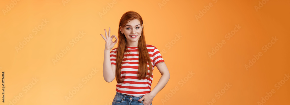 Very good. Pleased cute female showing okay sign and smiling satisfied ...