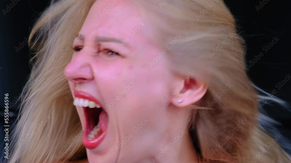 Close-up headshot of blonde woman screaming with her mouth wide open ...