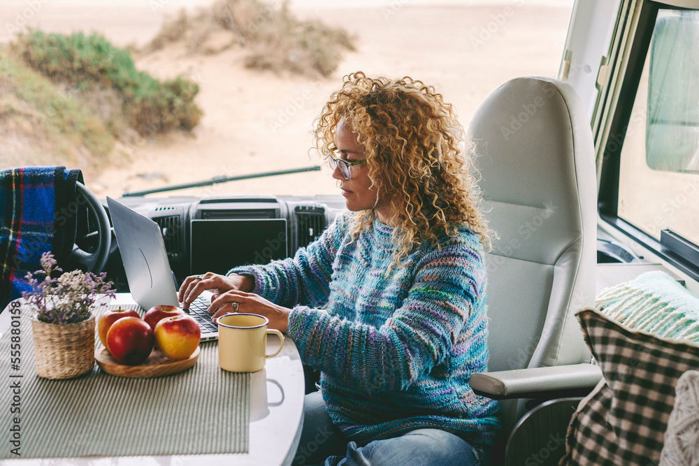 One modern female tourist working on laptop sitting inside a modern ...