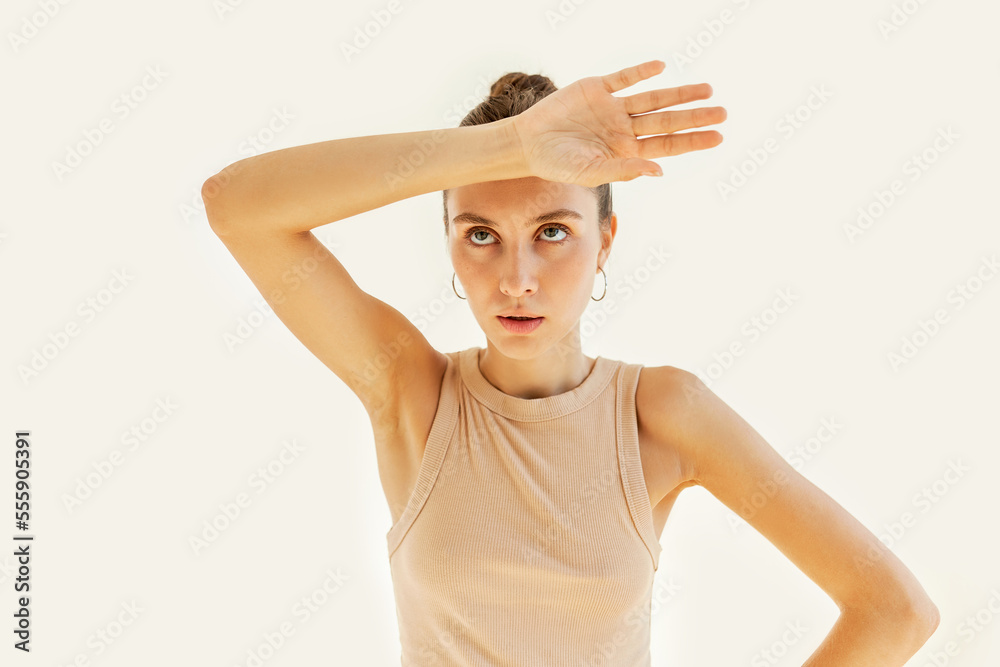 Studio image of beautiful caucasian female wiping forehead with hand ...