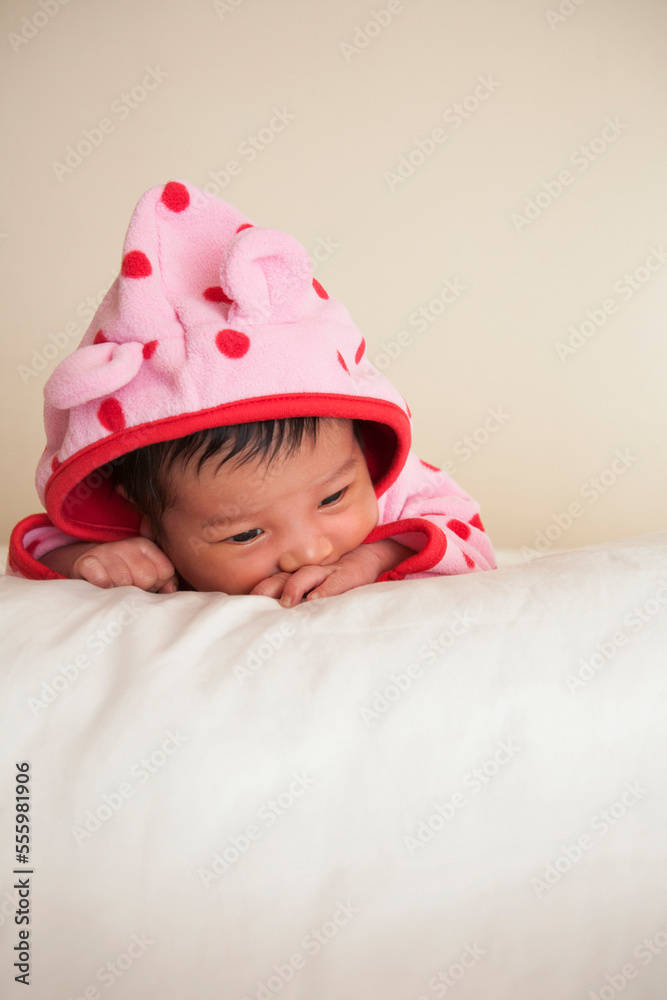 Portrait of two week old, newborn Asian baby girl in pink polka dot ...