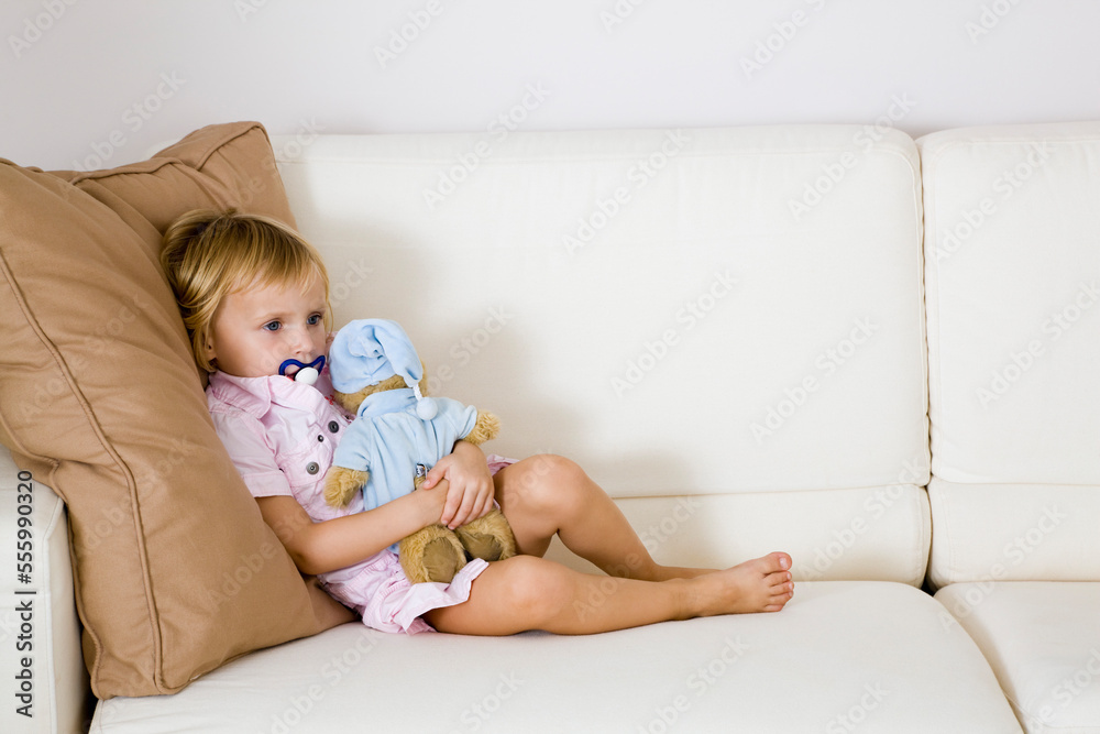 Little Girl Sitting on Sofa, Holding Stuffed Animal Stock Photo | Adobe ...